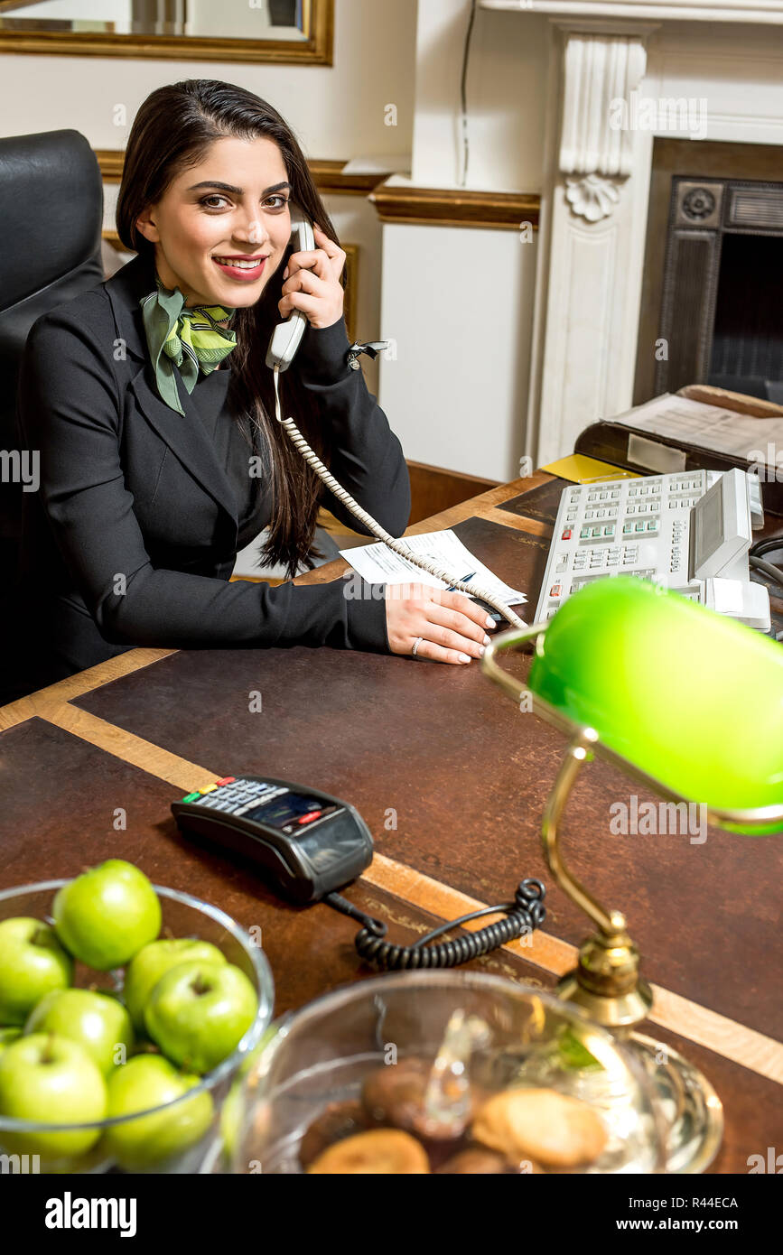 Female receptionist busy on call Stock Photo - Alamy