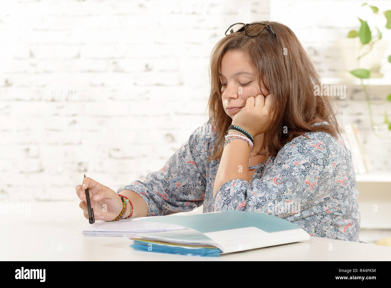 student girl, with eyeglasses, does homework Stock Photo - Alamy