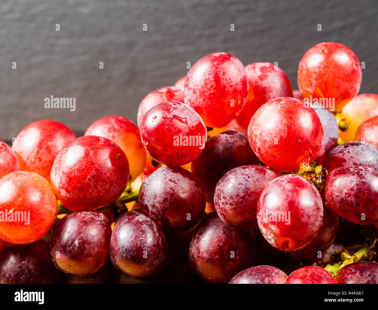 Grapes on wooden table, close-up.Bunches of fresh ripe red grapes on a ...
