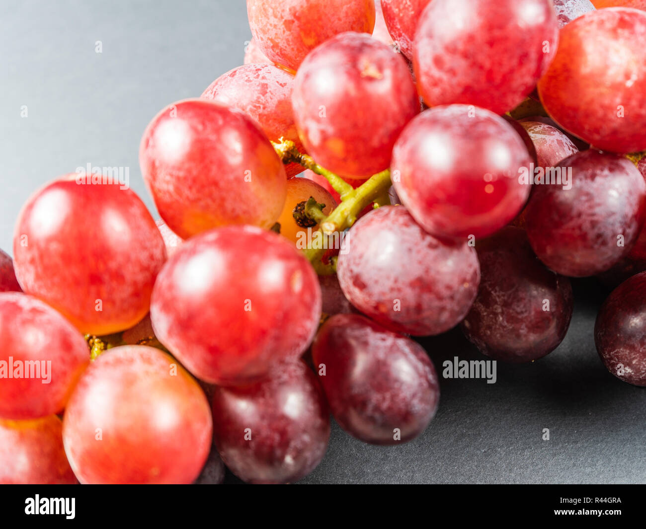 Grapes on wooden table, close-up.Bunches of fresh ripe red grapes on a ...