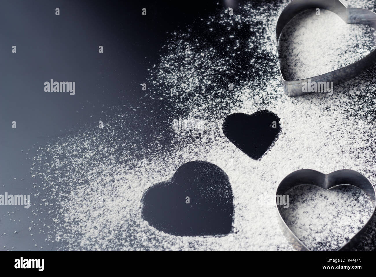 Baking background with heart shape and flour on dark table with copy ...