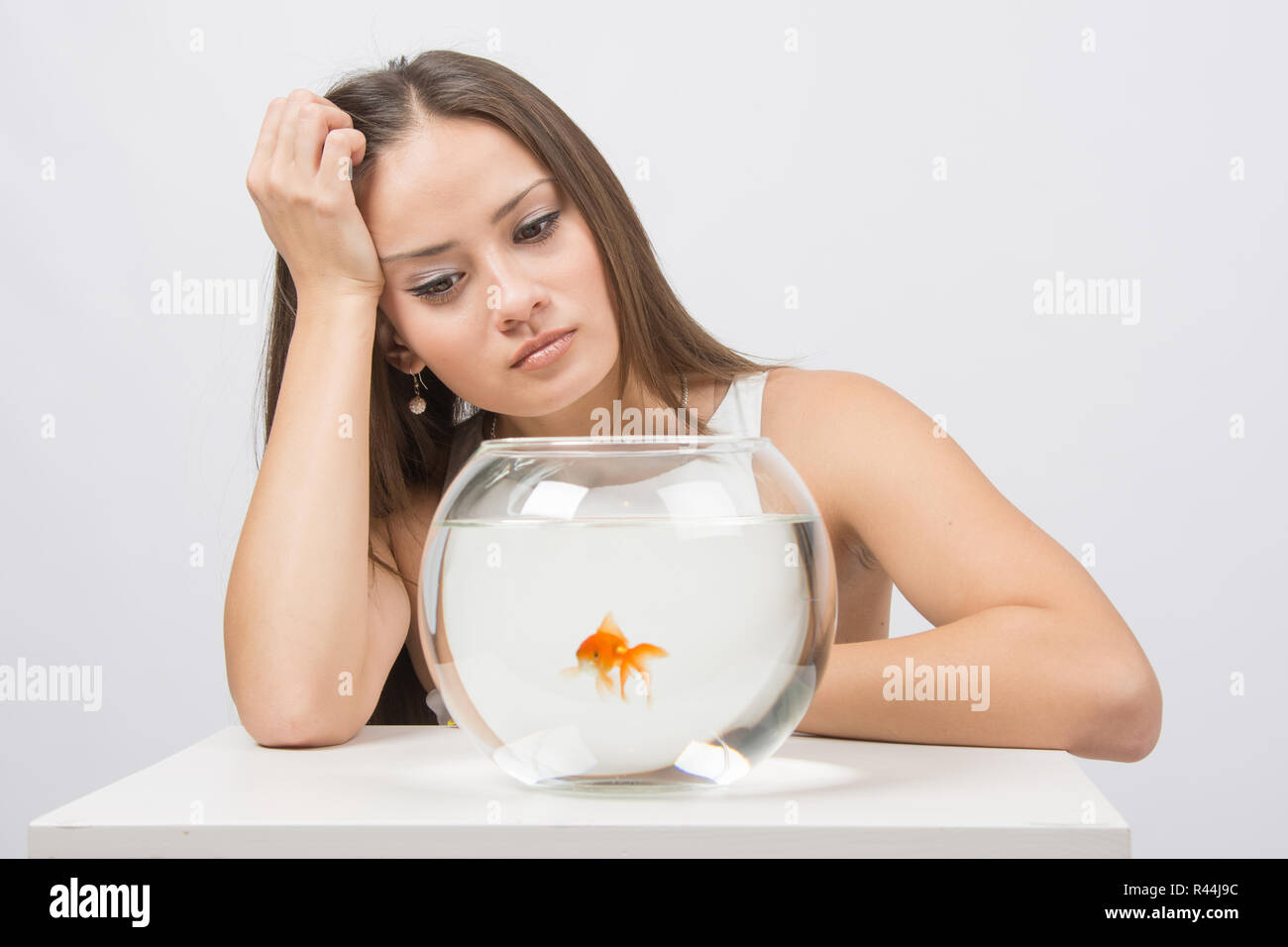 Upset young girl looking at goldfish in a fishbowl Stock Photo - Alamy