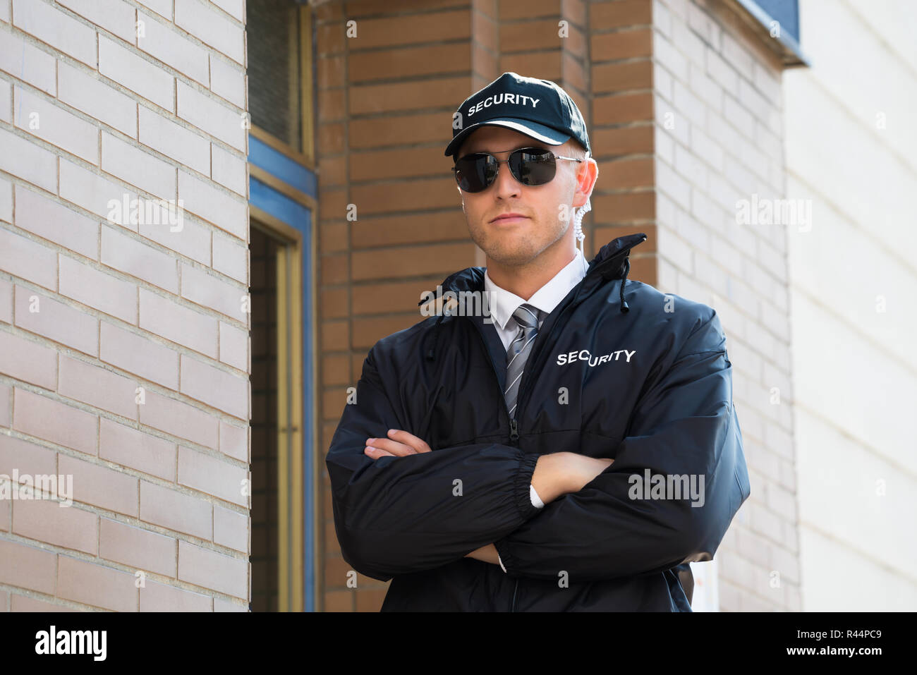 Security Guard Standing With Arm Crossed Stock Photo - Alamy