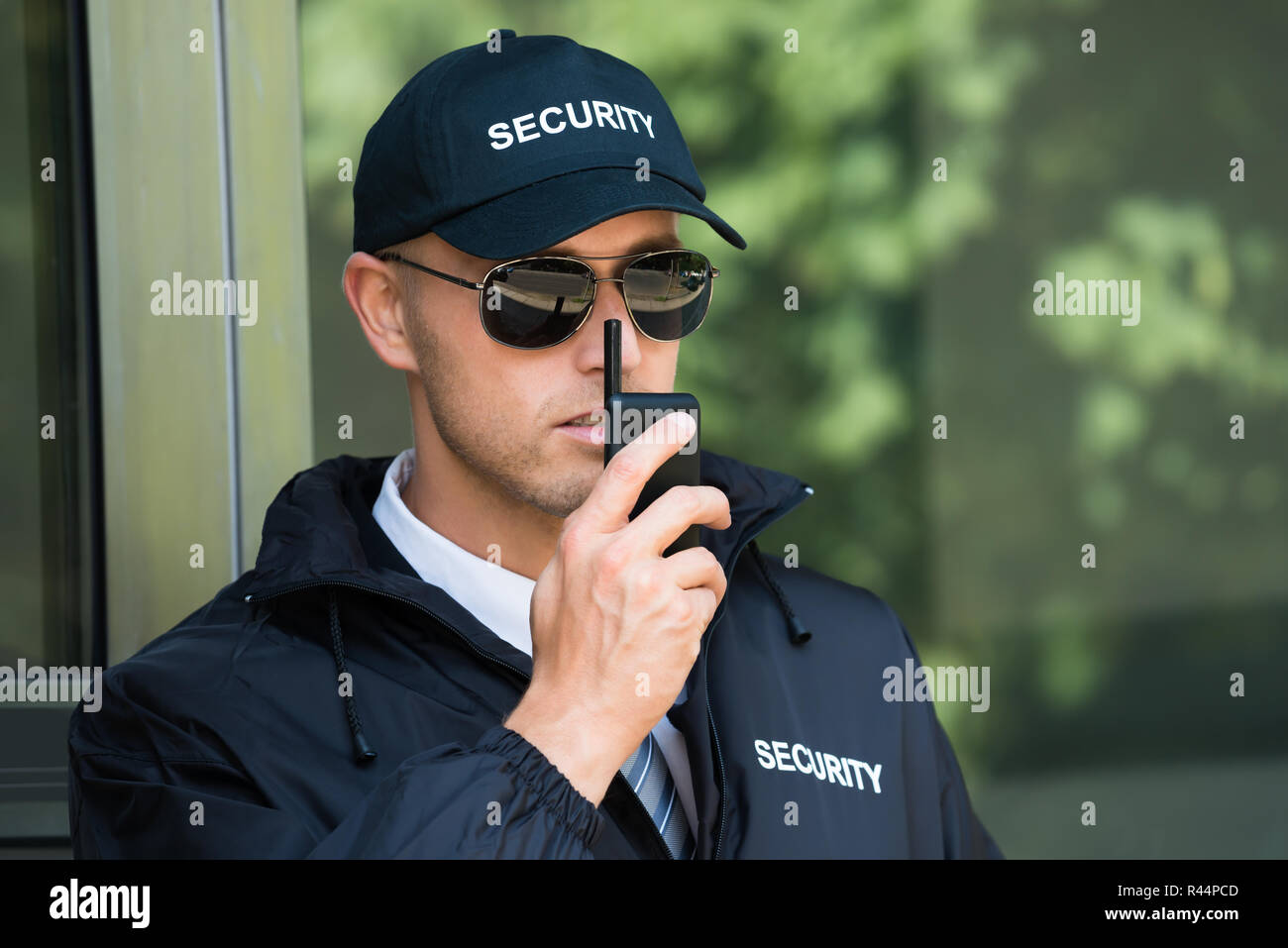 Young Security Guard Talking On Walkie-talkie Stock Photo - Alamy