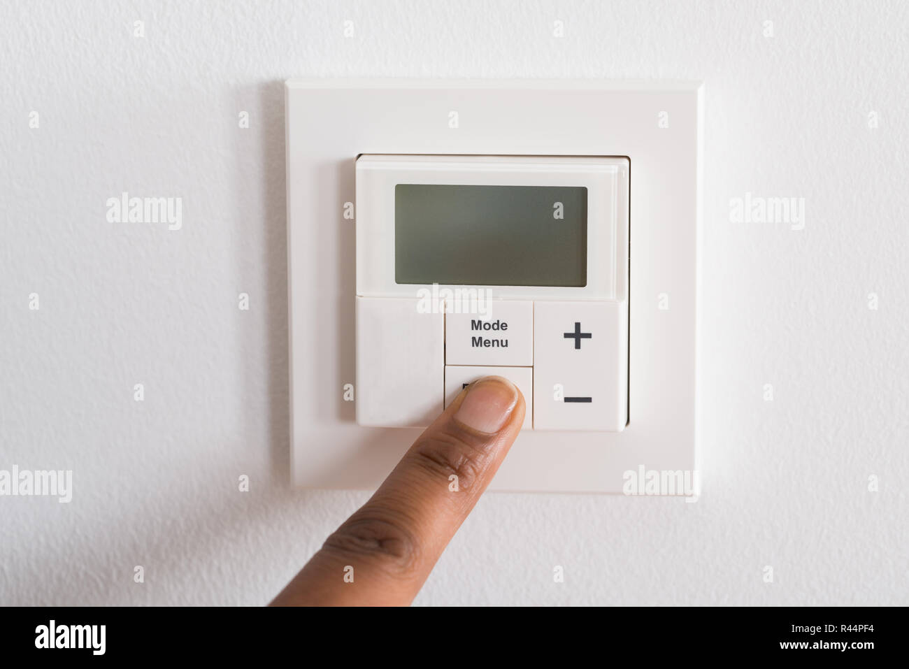 Person's Finger Adjusting Room Temperature On Digital Thermostat Stock ...