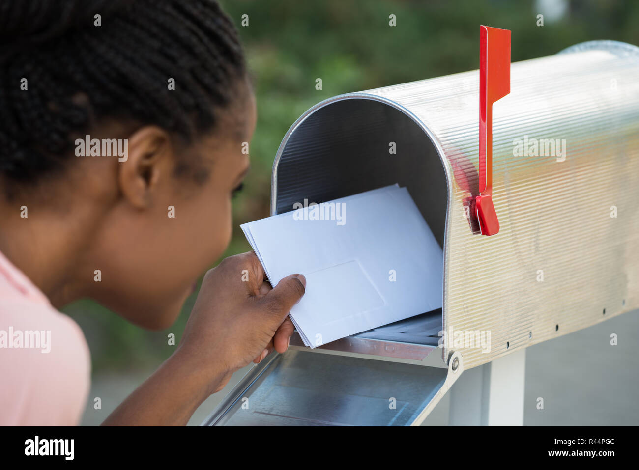 Woman Putting Letter In Mailbox Stock Photo - Alamy