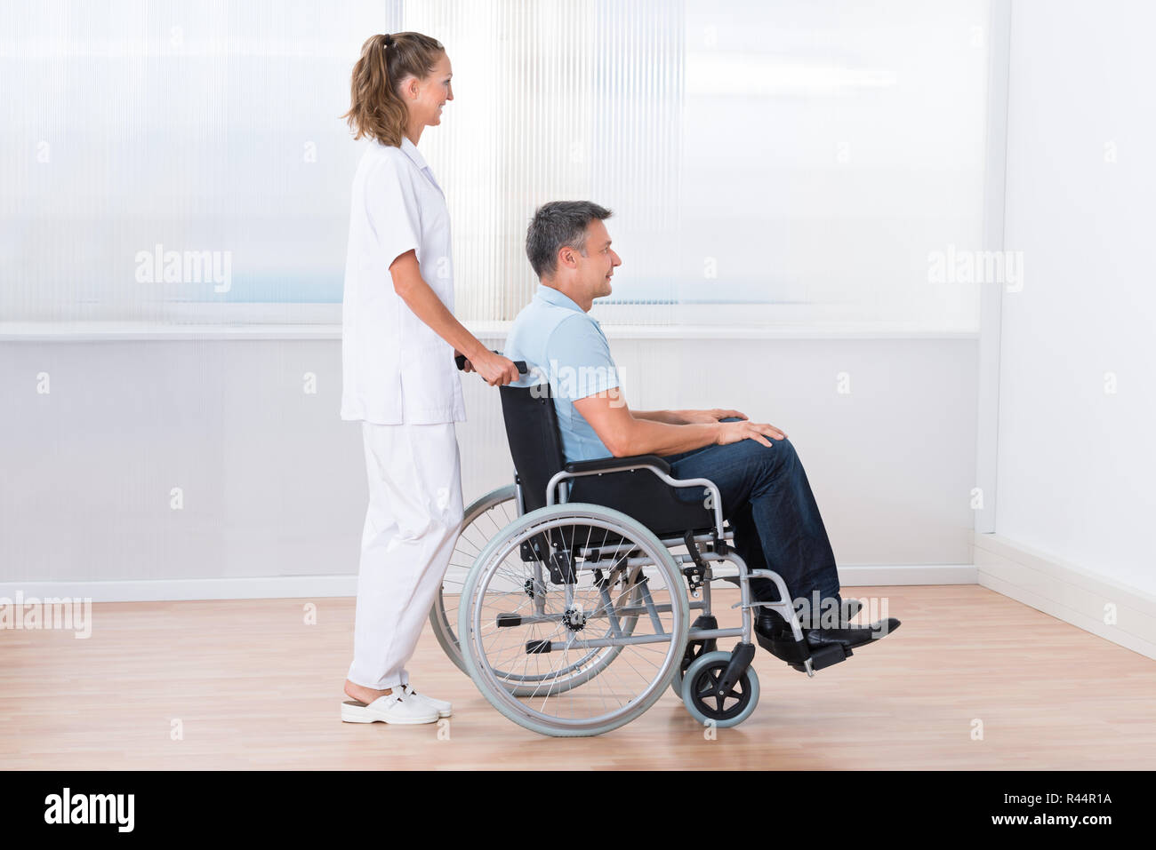 Doctor Pushing Disabled Patient On The Wheelchair Stock Photo - Alamy