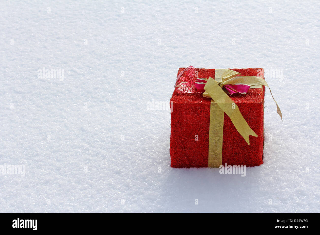 the large red and gold gift in the snow - a christmas present Stock ...