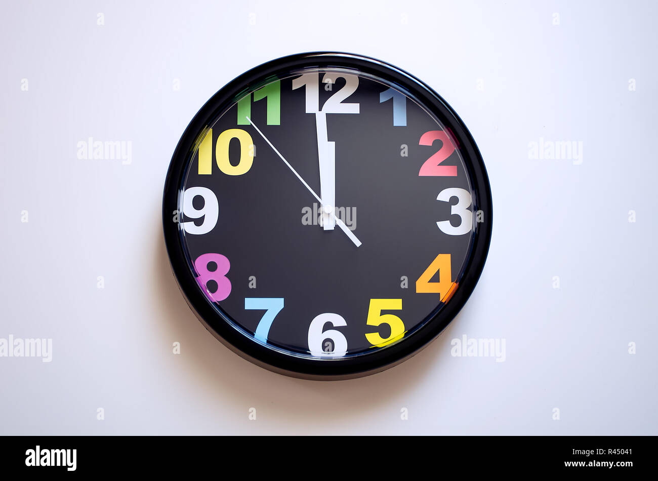 Clock on a white background. A few seconds to midnight. Multi-colored ...