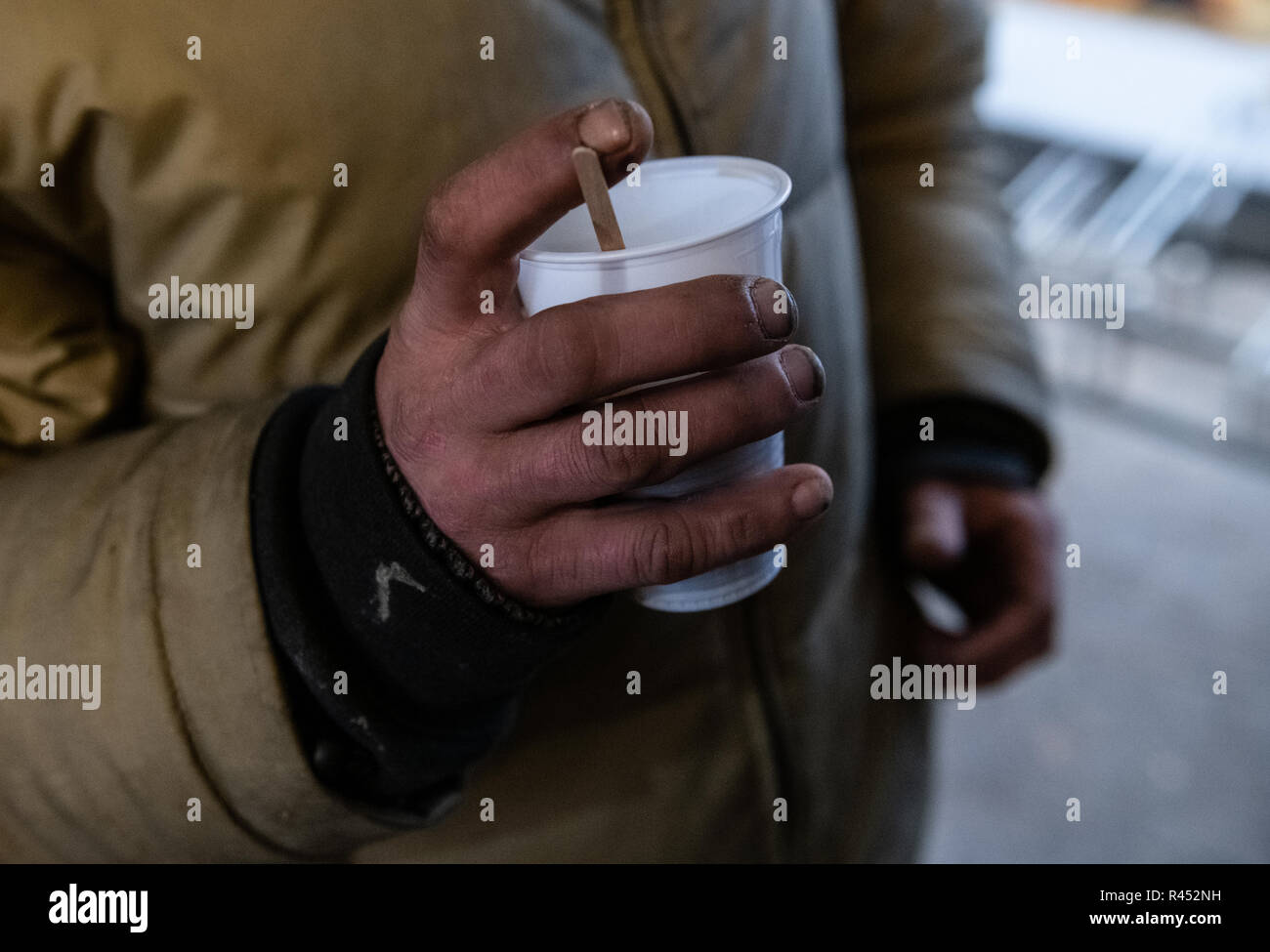 Berlin, Germany. 24th Nov, 2018. A homeless person is holding a cup ...