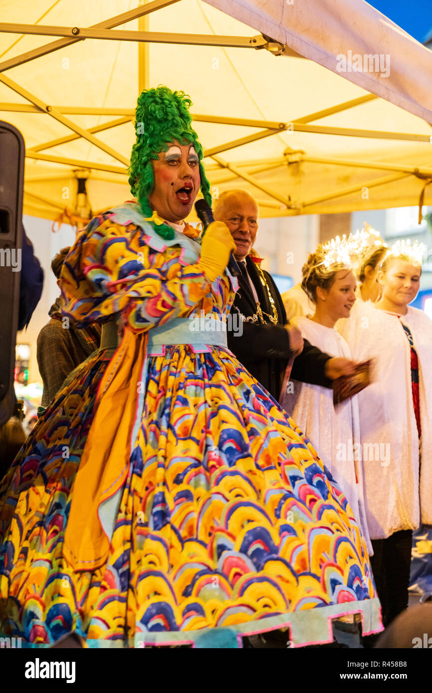 Pantomime queen, man in drag, woman's clothing, with green wig holding ...