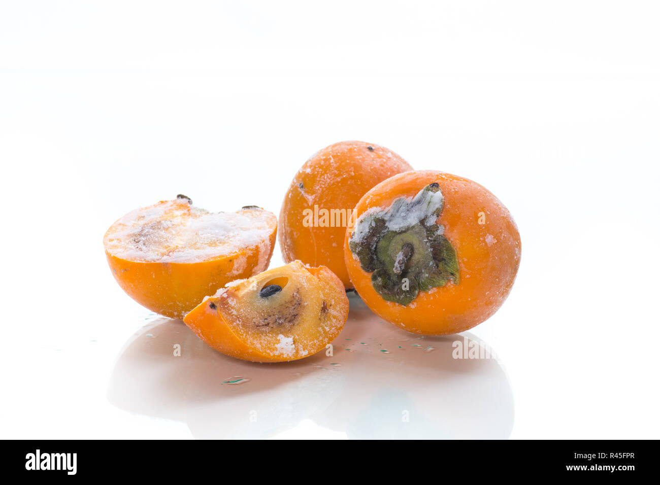 frozen ripe persimmon in ice isolated on white Stock Photo - Alamy
