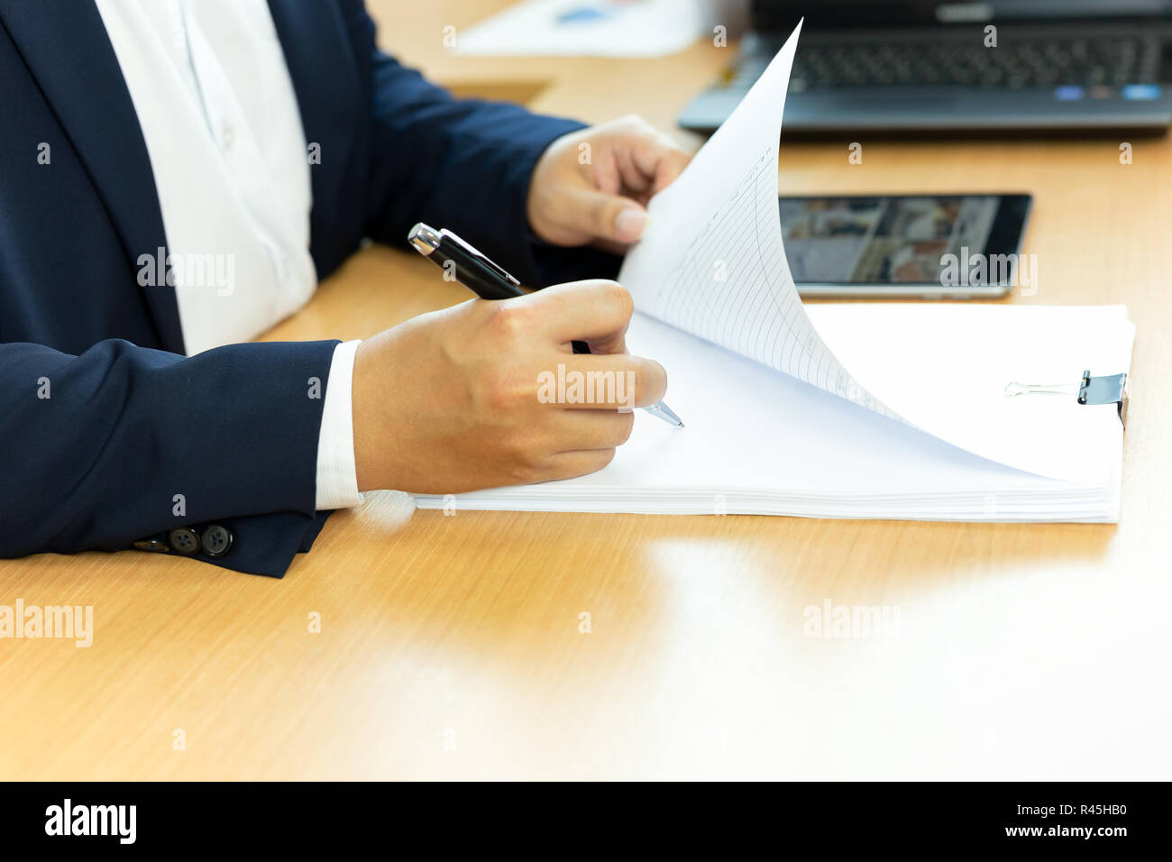 Businessman signing contract paper with pen in office desk Stock Photo ...