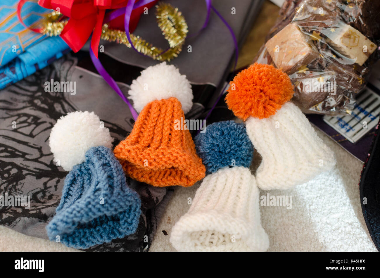 Colorful knitted miniature bonnets under the Christmas tree Stock Photo ...