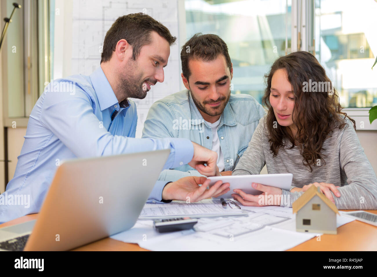 Young attractive people meeting real estate agent at the office Stock ...