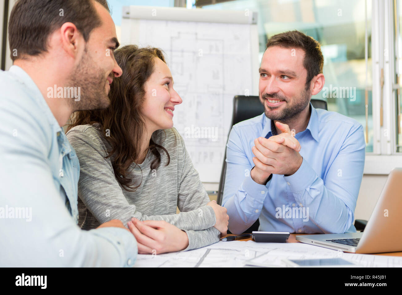 Young attractive people meeting real estate agent at the office Stock ...