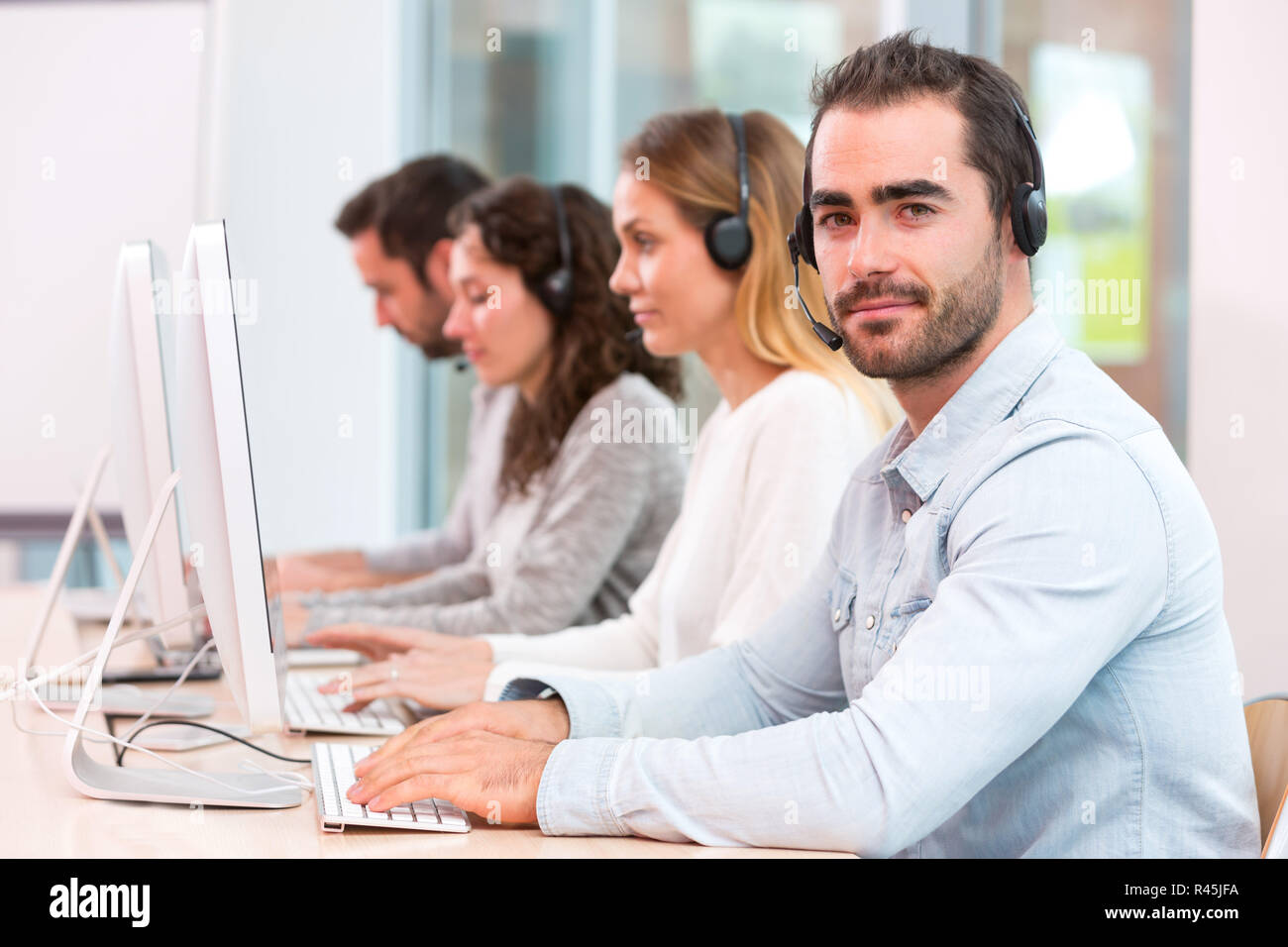 Young attractive man working in a call center Stock Photo - Alamy