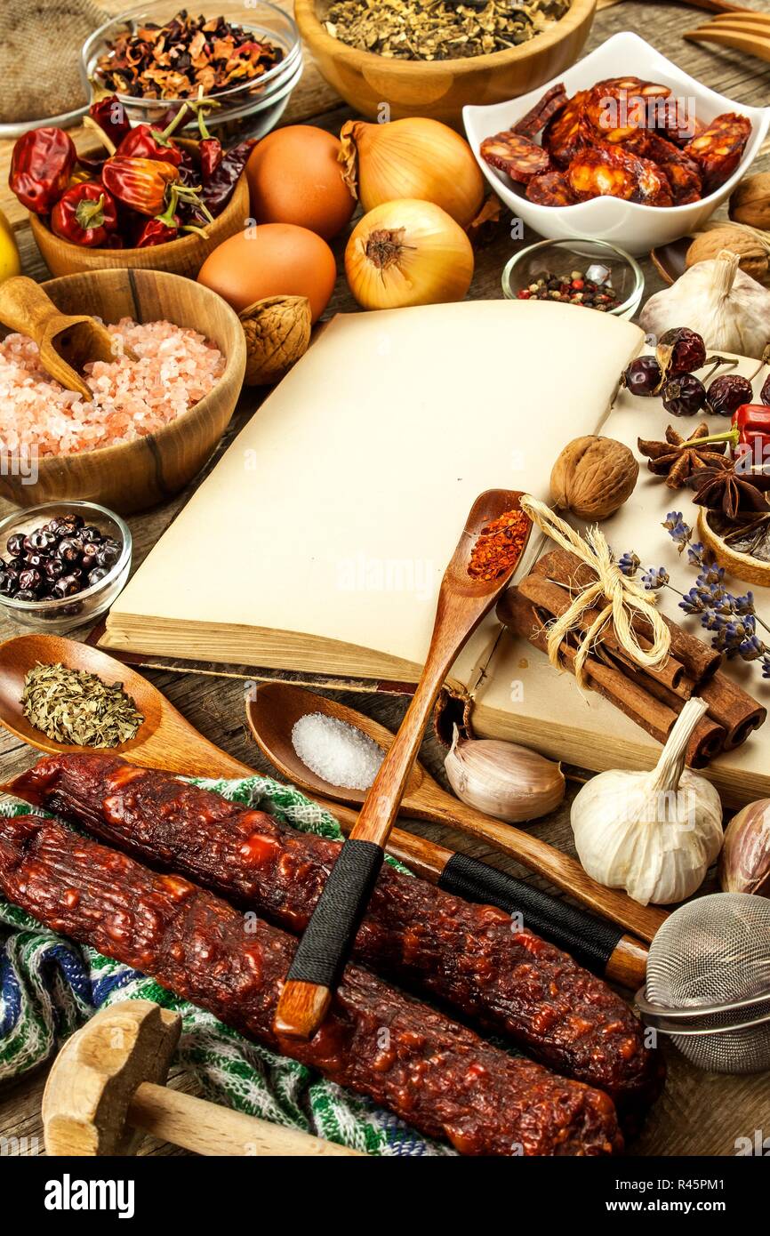 Cookbook and spice on a wooden table. Food preparation. An old book in ...