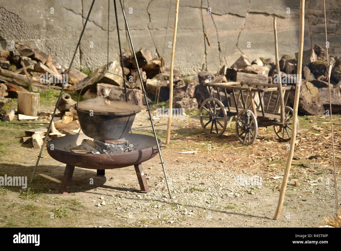 medieval pots on a hearth with wood and a cart Stock Photo - Alamy