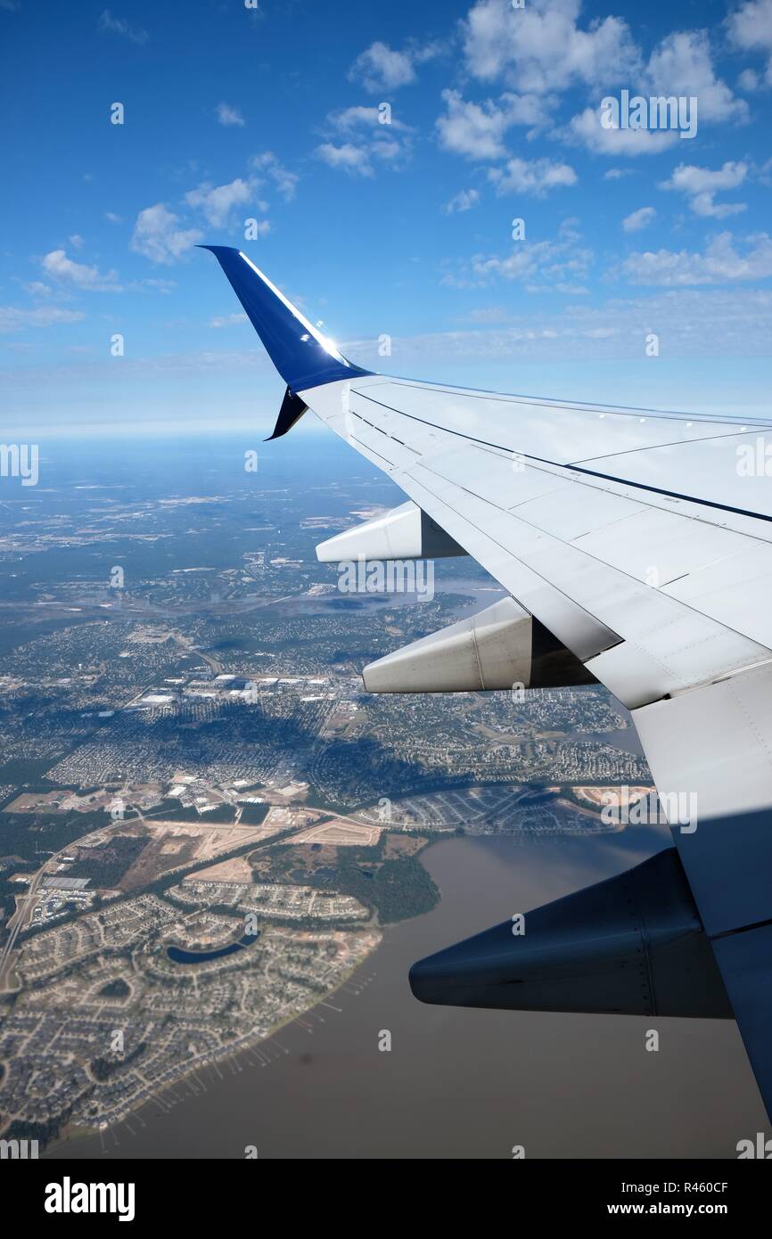 View of wing, clouds and earth below from an Delta Airlines airplane ...