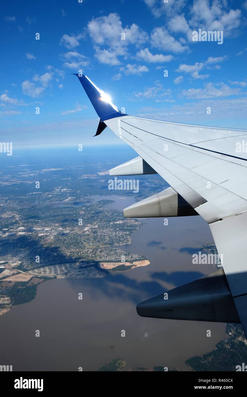 View of wing, clouds and earth below from an Delta Airlines airplane ...