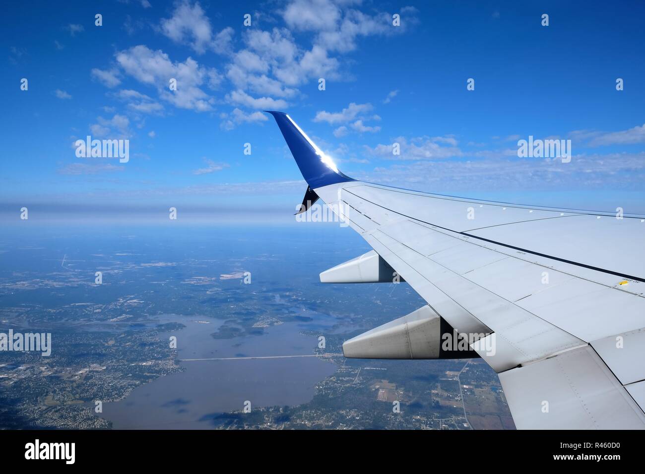 View of wing, clouds and earth below from an Delta Airlines airplane ...