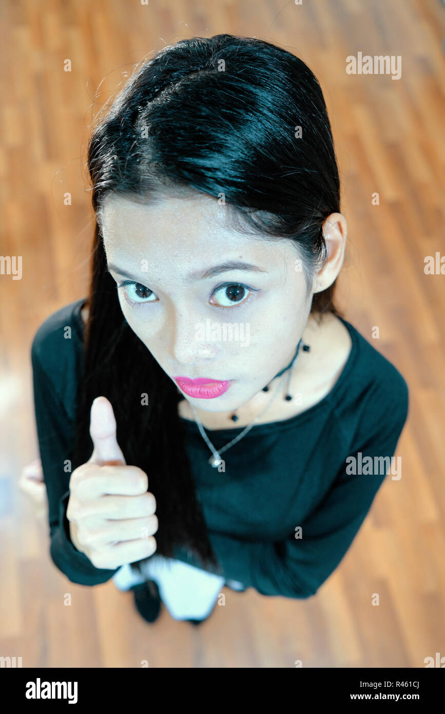 Beautiful woman posing - look up, facial expression, thumbs up, hand ...