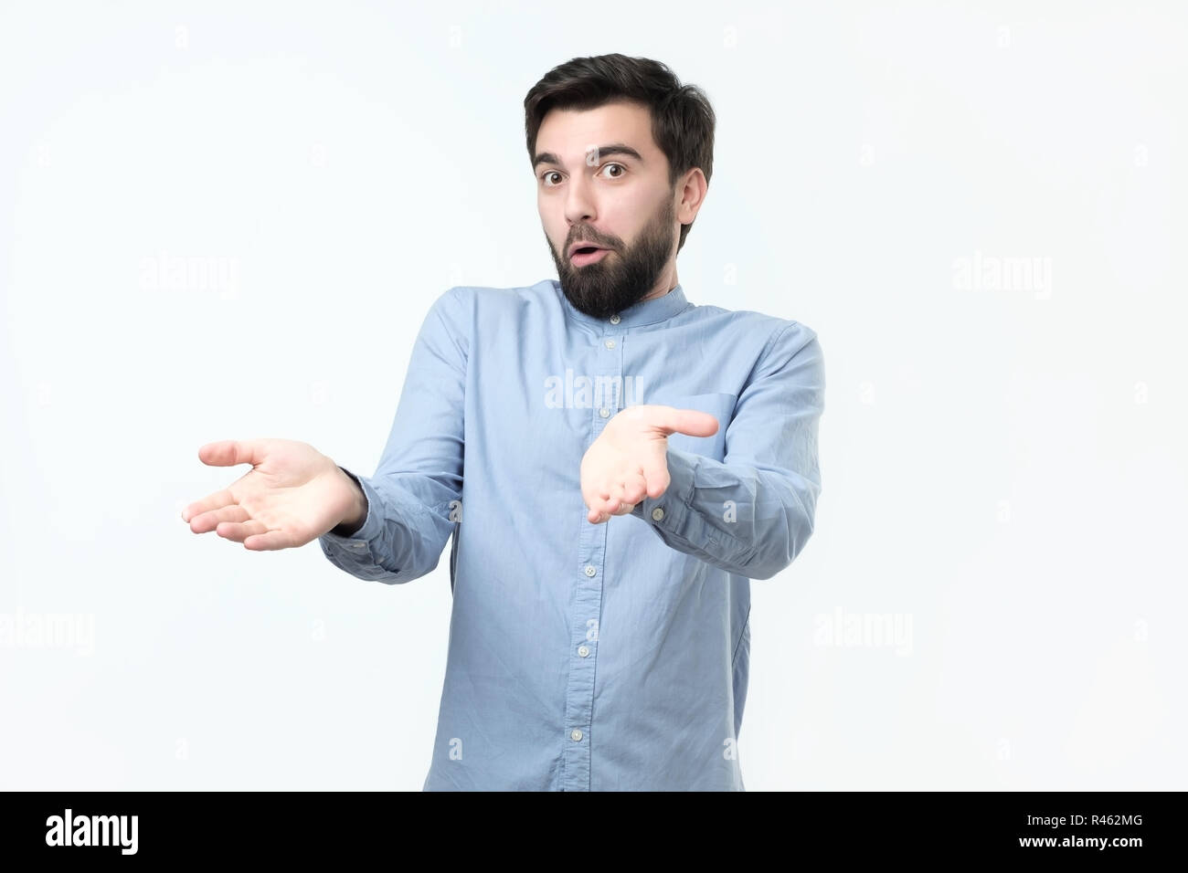 Hispanic young man with a beard is indignant and throwing up hands ...