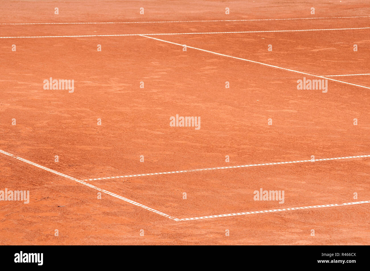 Part of empty used red clay tennis court playground surface with white ...