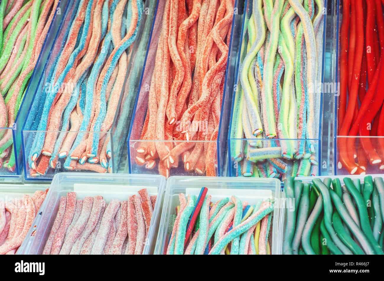 Multicolor tasty licorice candies in plastic containers. Sweet delight ...