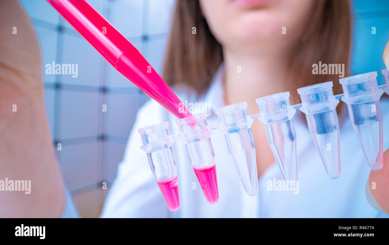 Young woman fill PCR microtubes with dispenser Stock Photo - Alamy