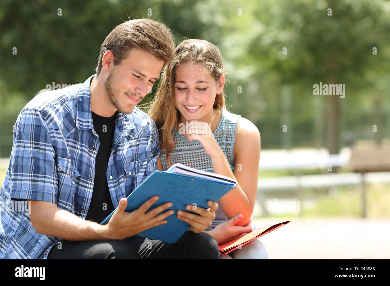 Couple of happy students learning together sitting in a campus Stock ...