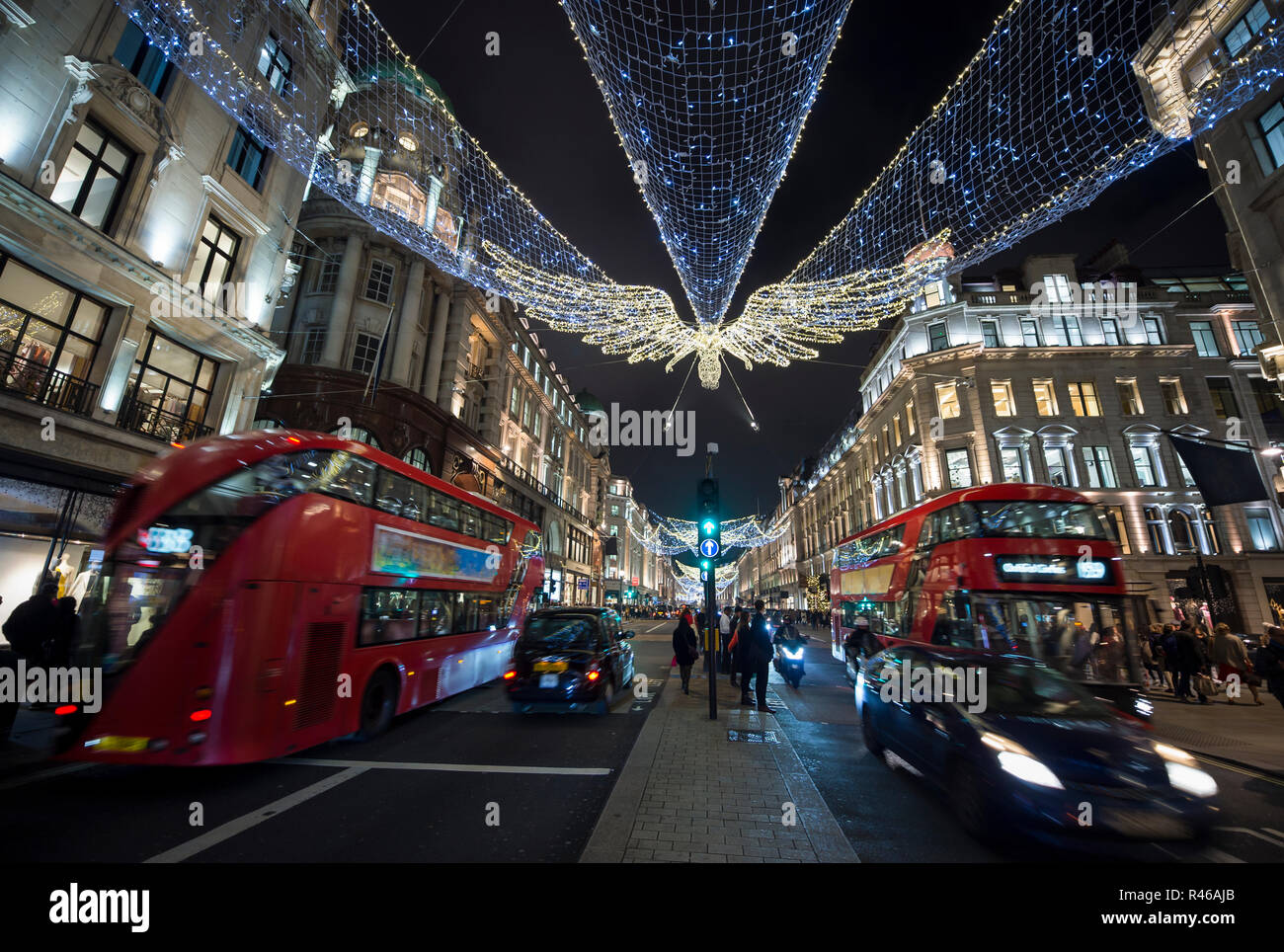 Busy holiday shopping scene with double decker buses and black cabs ...