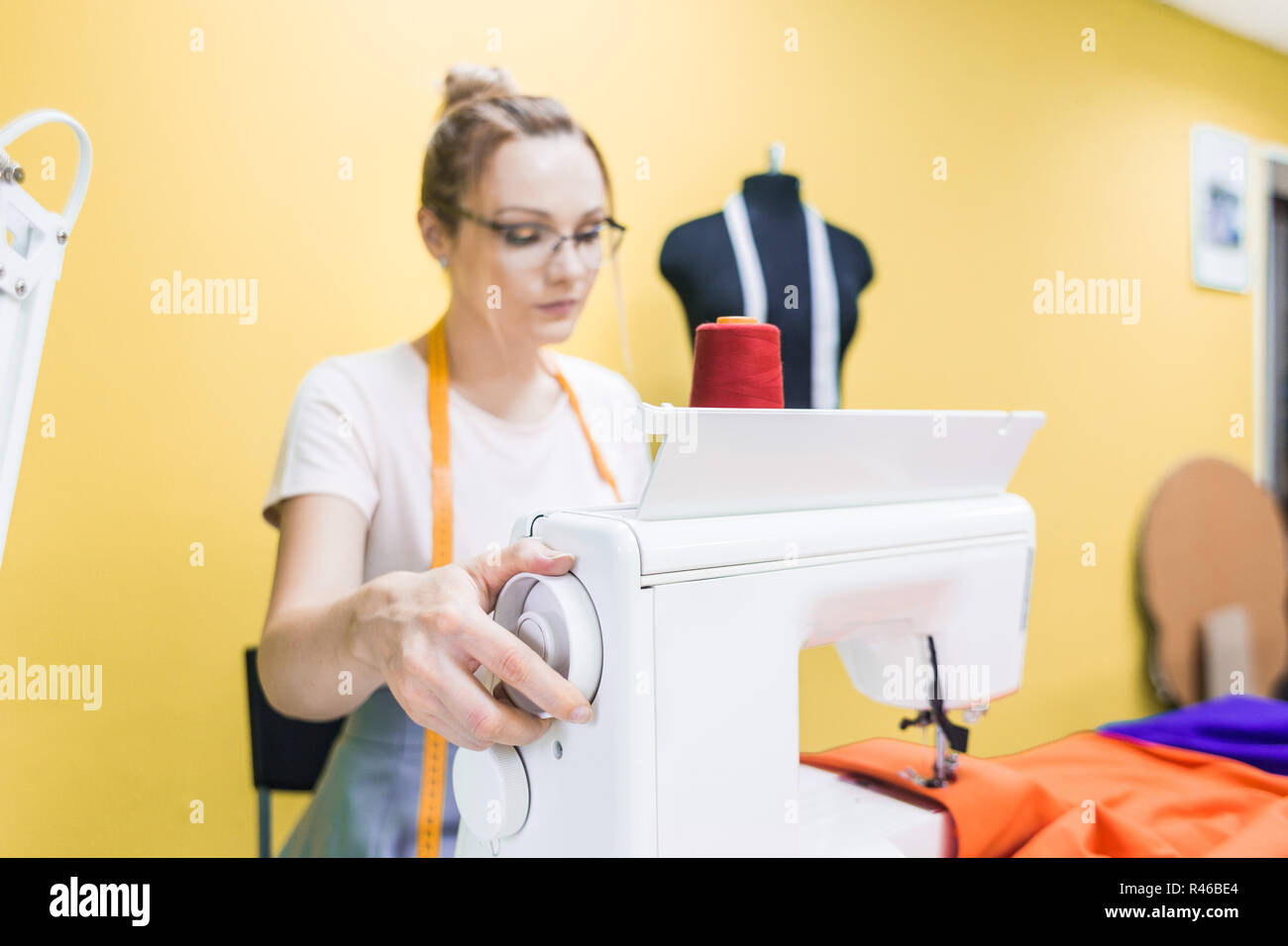 Sewing workshop. Seamstress at work. Young woman working with sewing ...