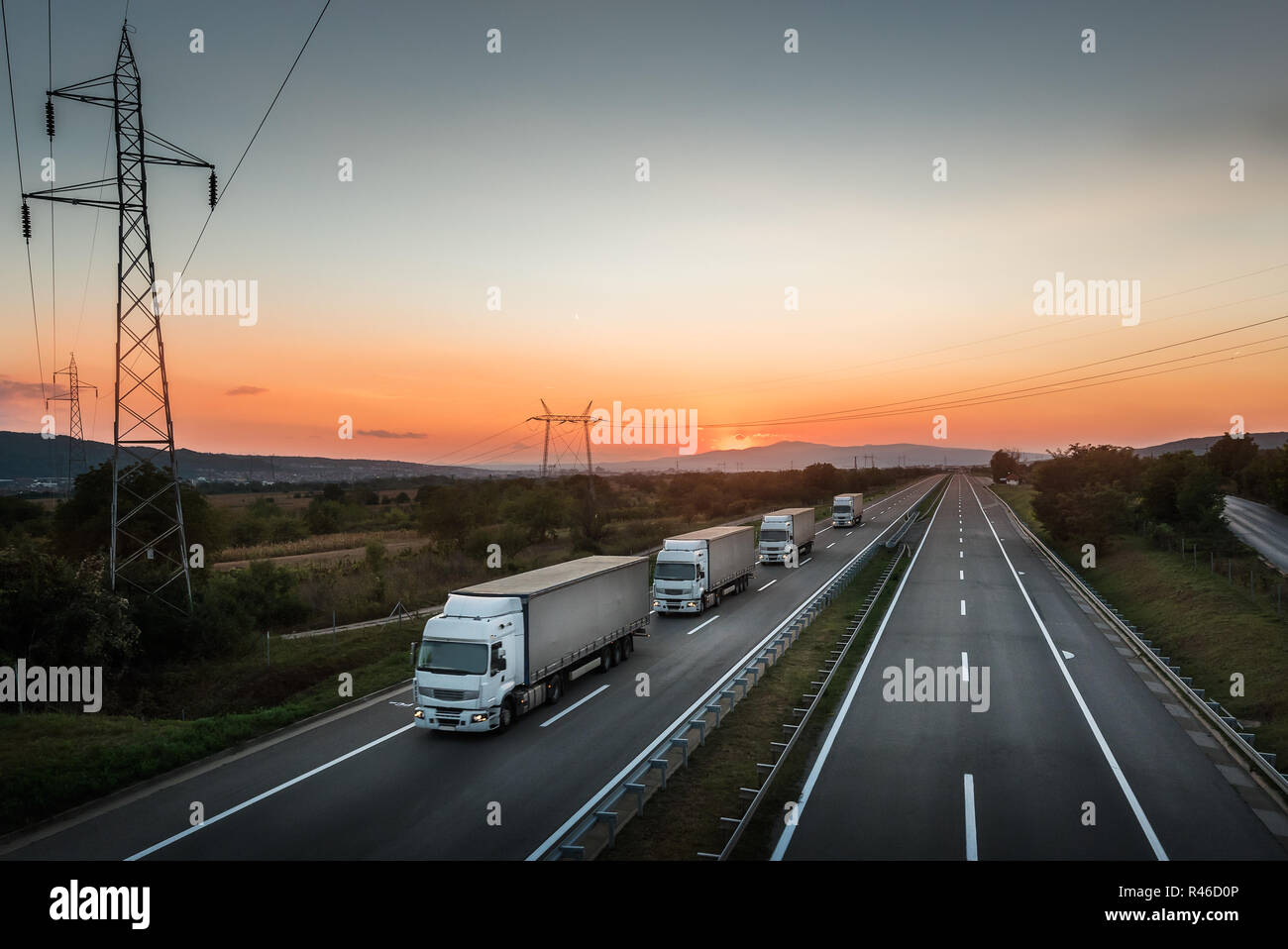 Four White Lorry Trucks Convoy on highway at beautiful sunset Four ...