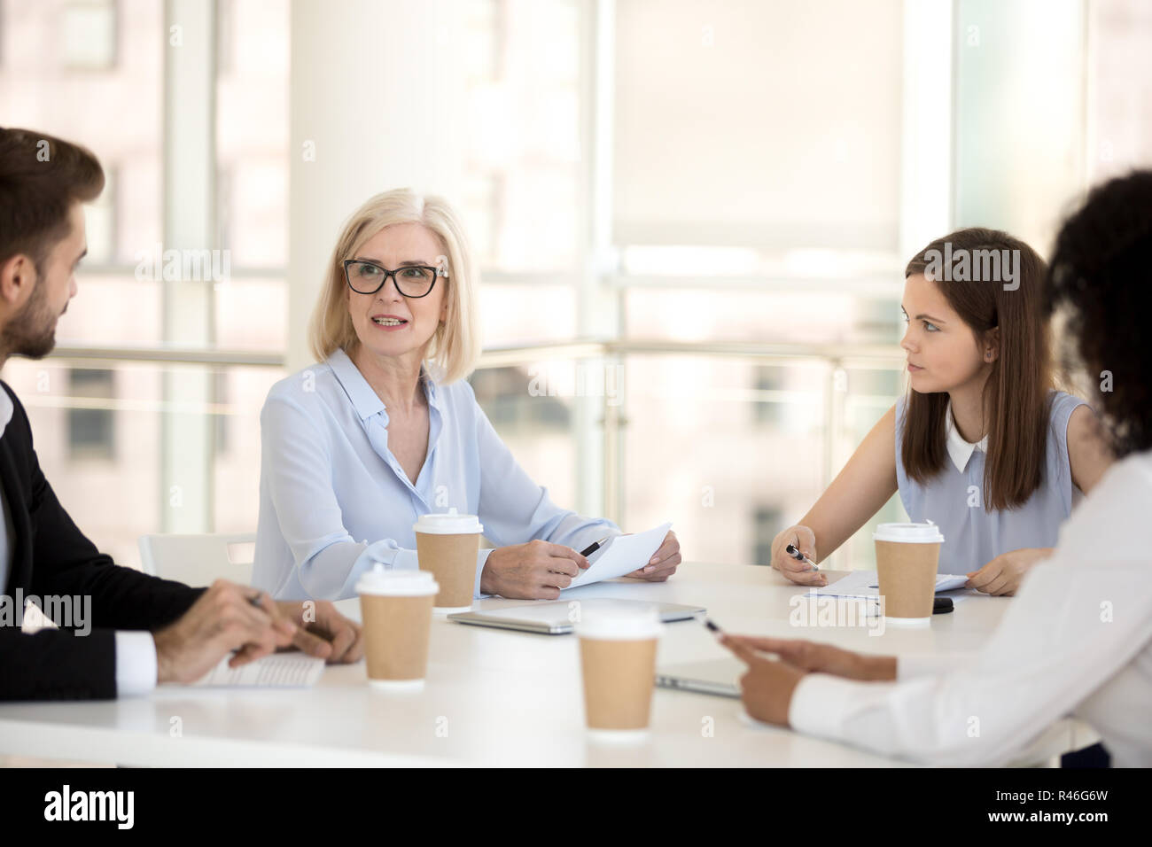 Serious mature executive speaking at office briefing to employee Stock ...