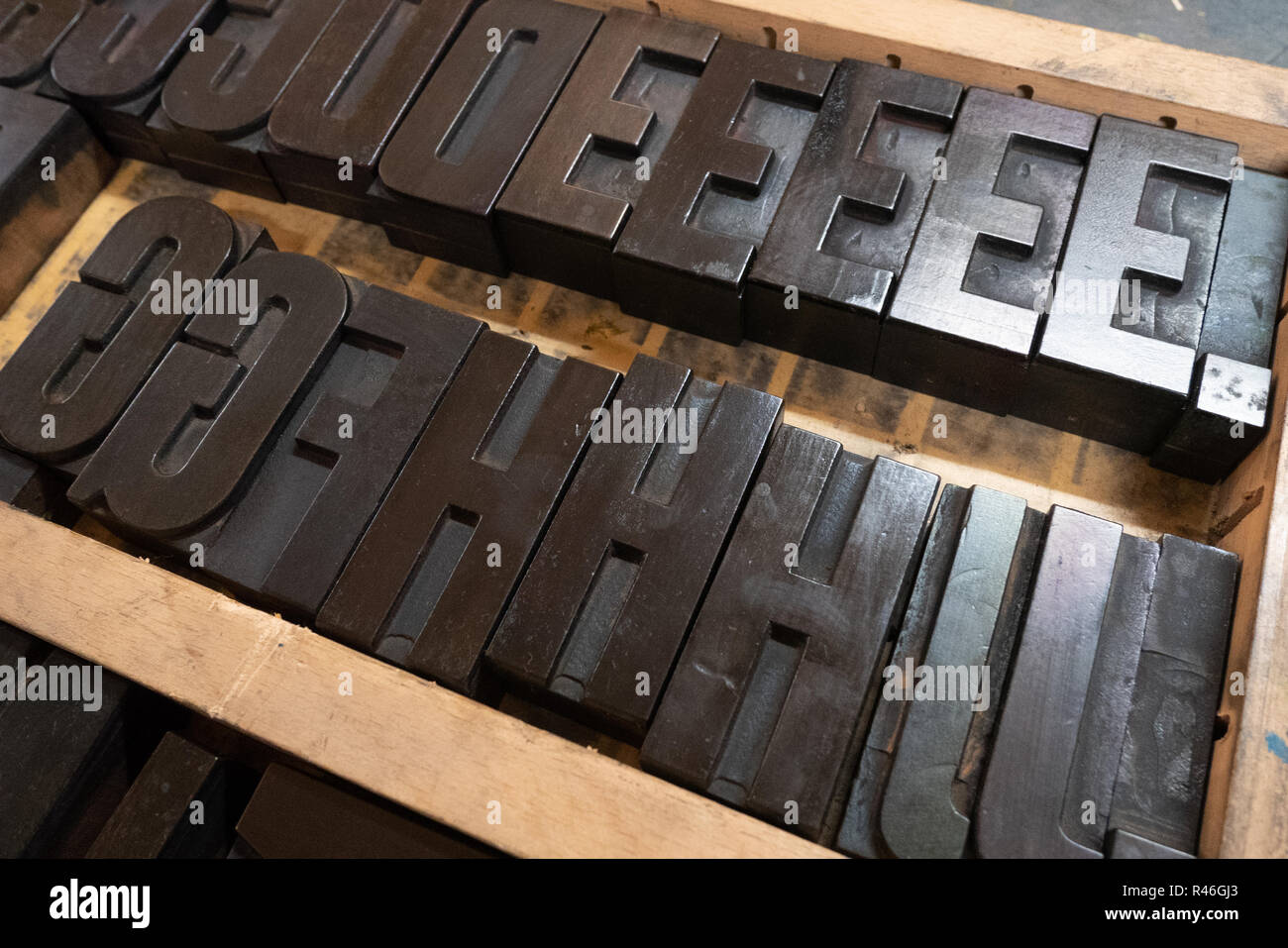 Jumble of different metal letters in a tray for use in an old ...