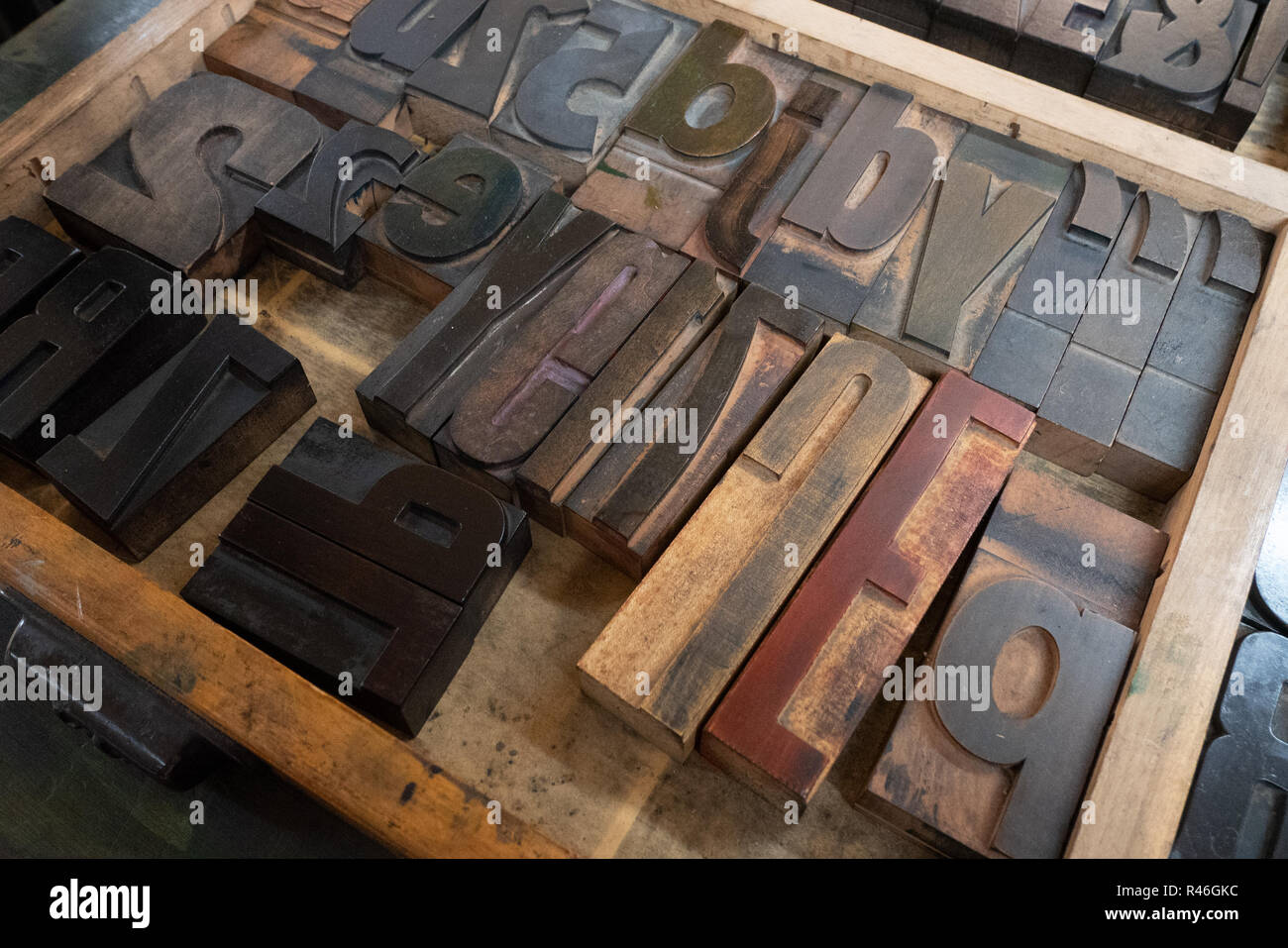 A set of large sans serif metal and wooden letters laid on a tray ready ...