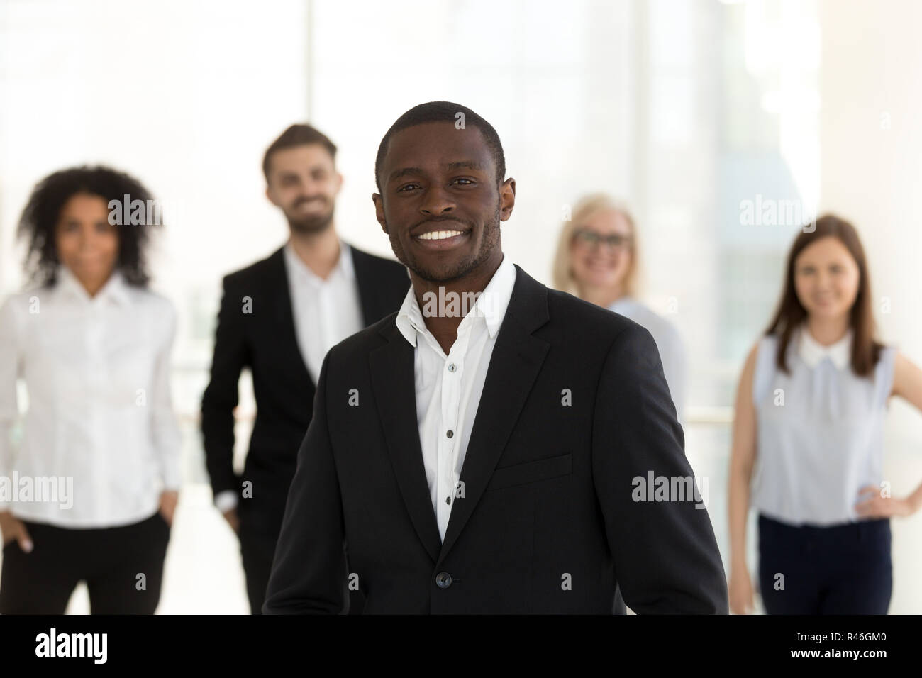 Smiling african corporate leader posing with diverse team in off Stock ...