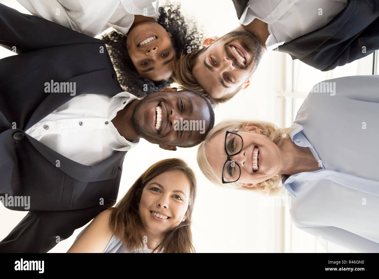 Happy diverse business team gathering in circle looking at camer Stock ...
