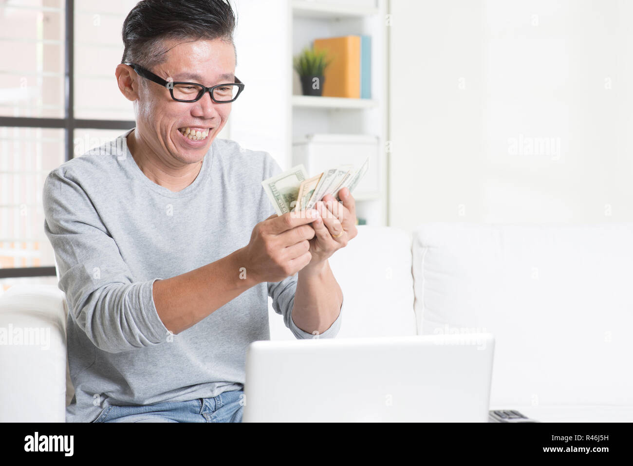 Mature Asian man counting money Stock Photo - Alamy