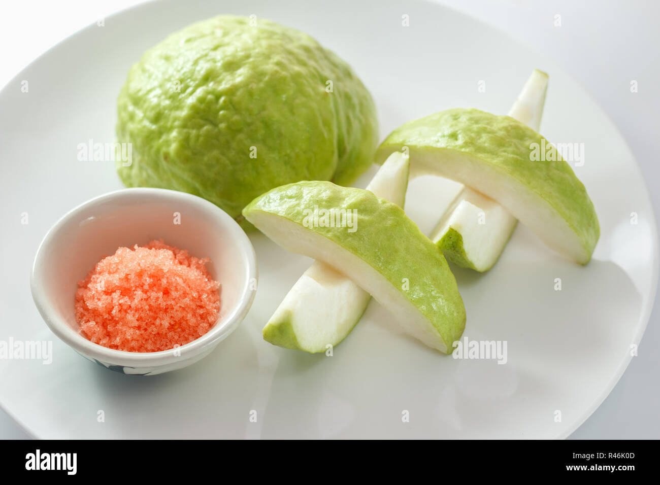 Fresh organic guava fruit and red pepper and salt isolated on a white ...