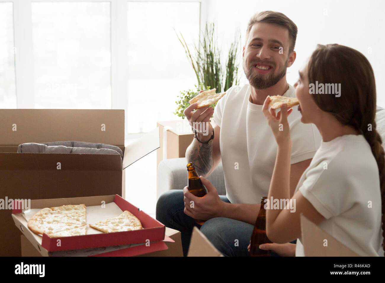 Young couple eating pizza housewarming party, celebrating moving Stock ...