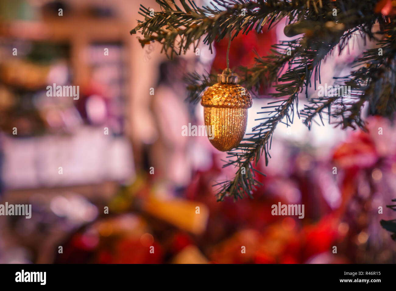 Close up of golden acorn Christmas ornament on branch of Christmas tree ...