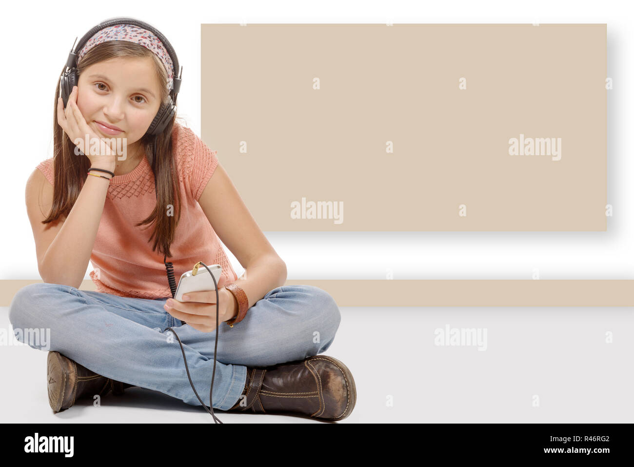 young teenager sitting cross-legged on the floor, listen music Stock ...