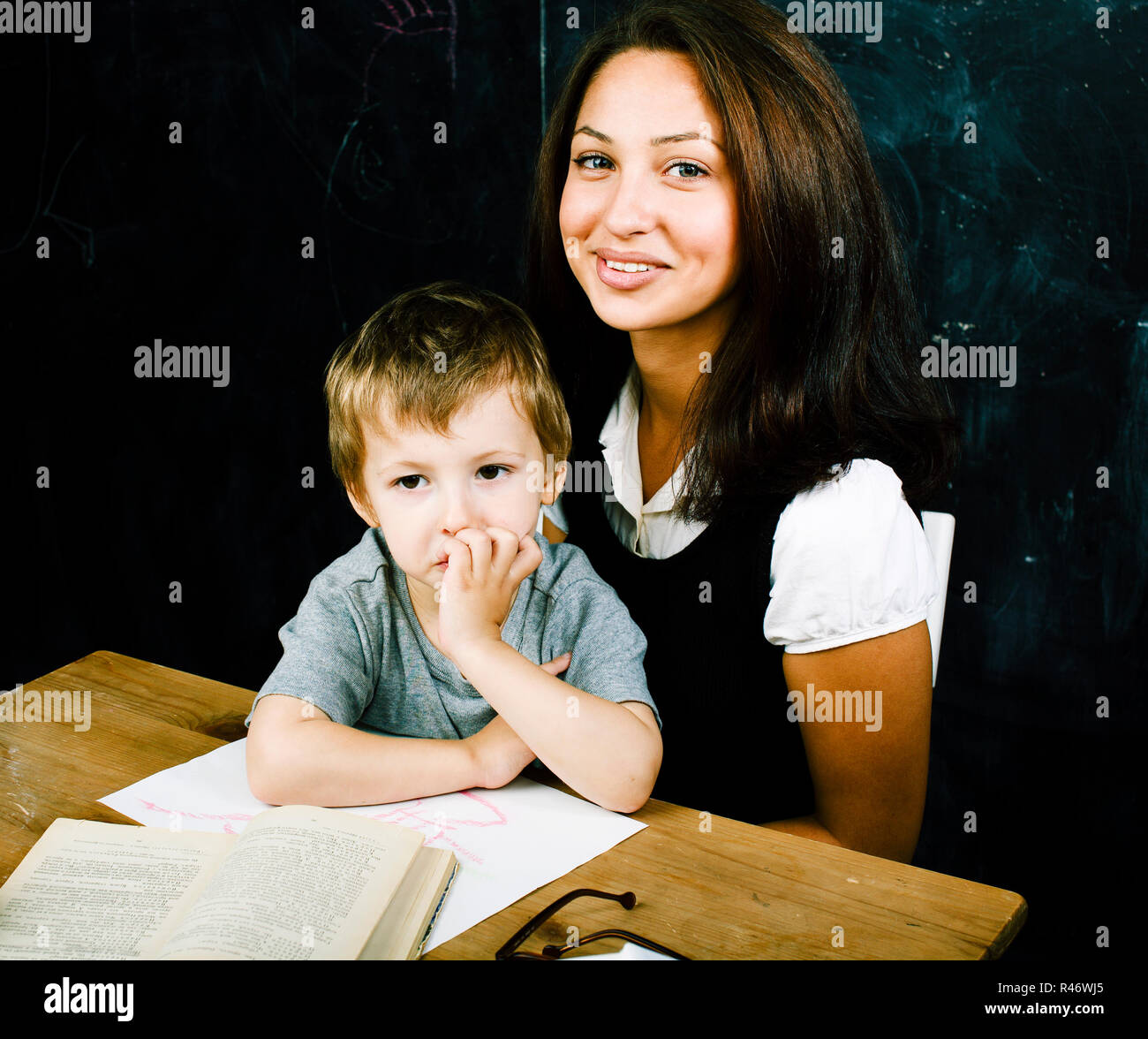 little cute boy pupil with young real teacher, classroom studyin Stock ...