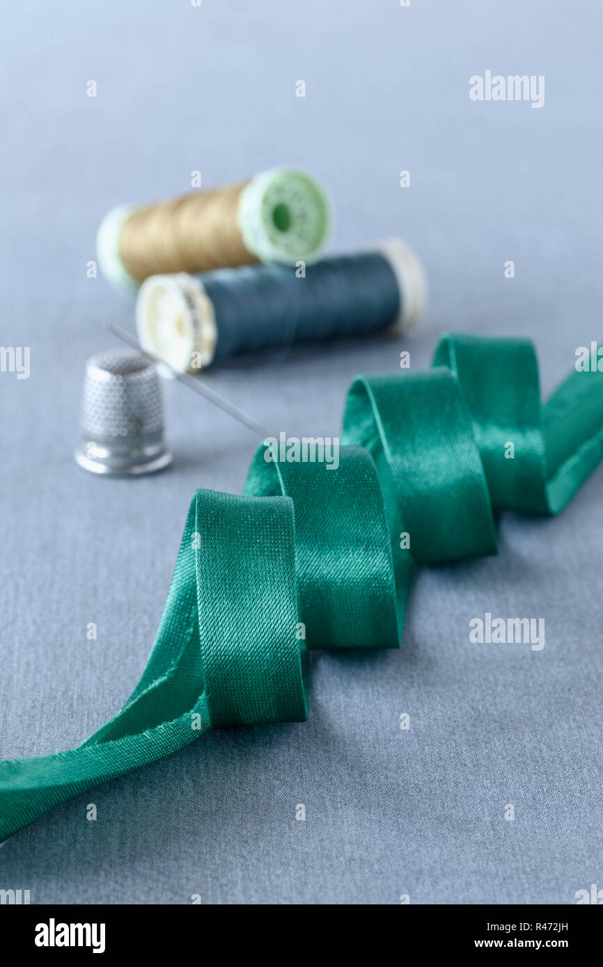Green satin Bias binding with thimble and cotton threads Stock Photo ...