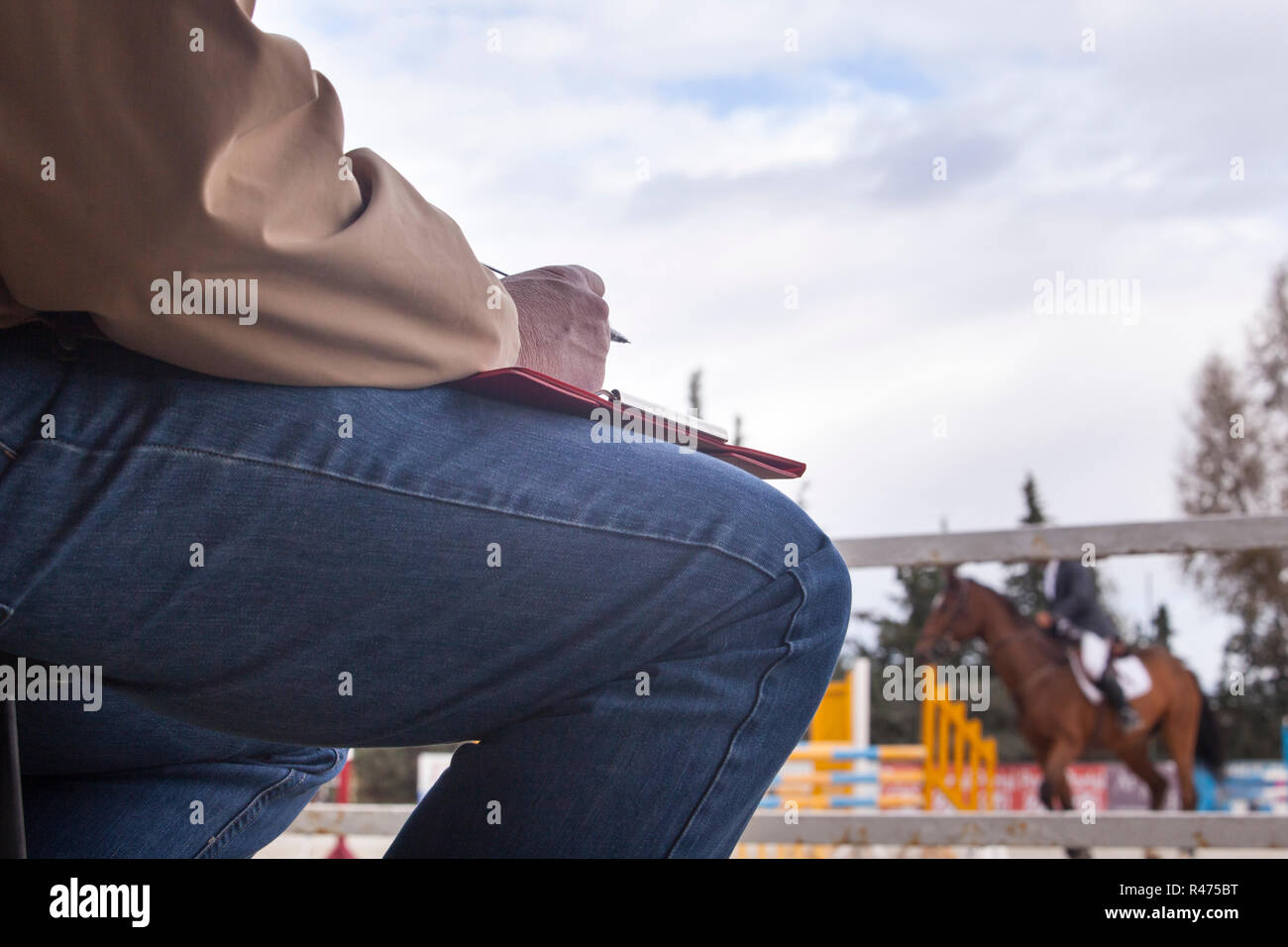 Judge writting down while a rider performs at horse jumping competition ...