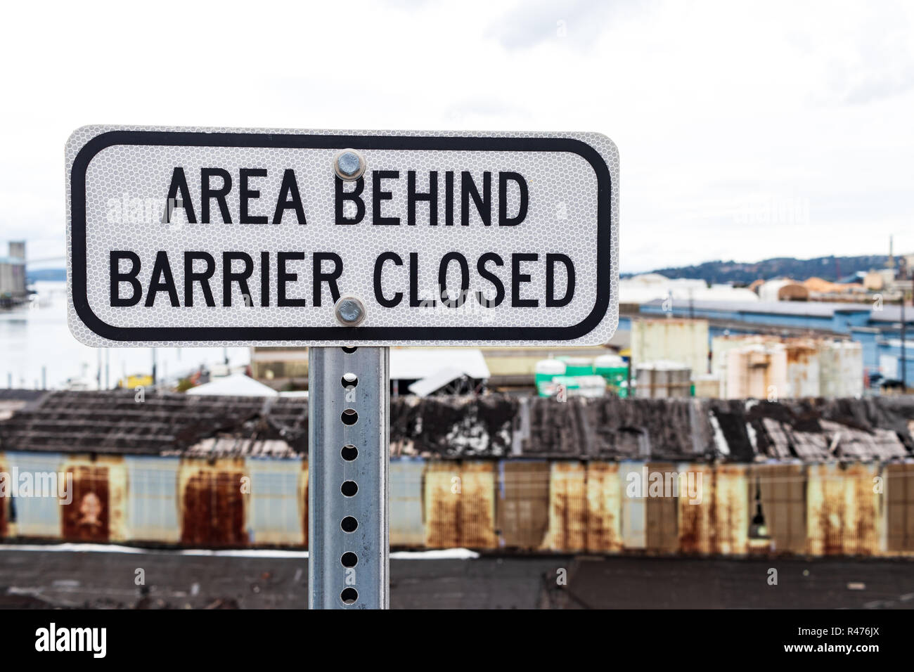 Area behind barrier closed sign with condemned abandoned building in ...