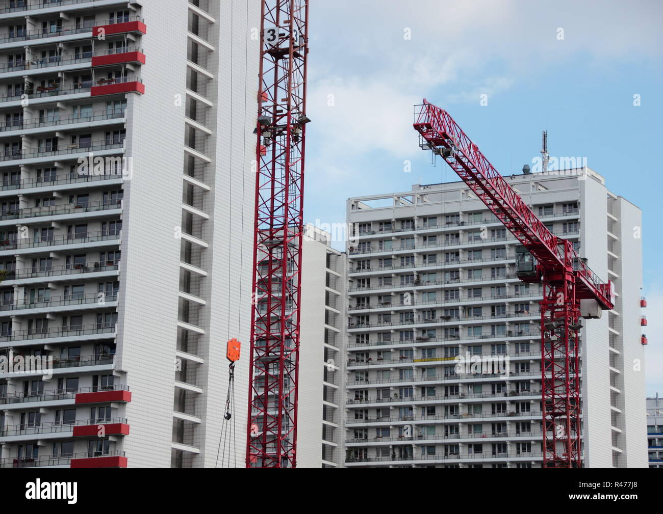 Red crane at construction site with building development Stock Photo ...
